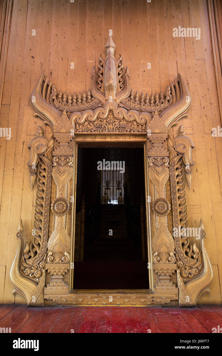 Ornate door and wooden exterior of a building at the royal Mandalay ...