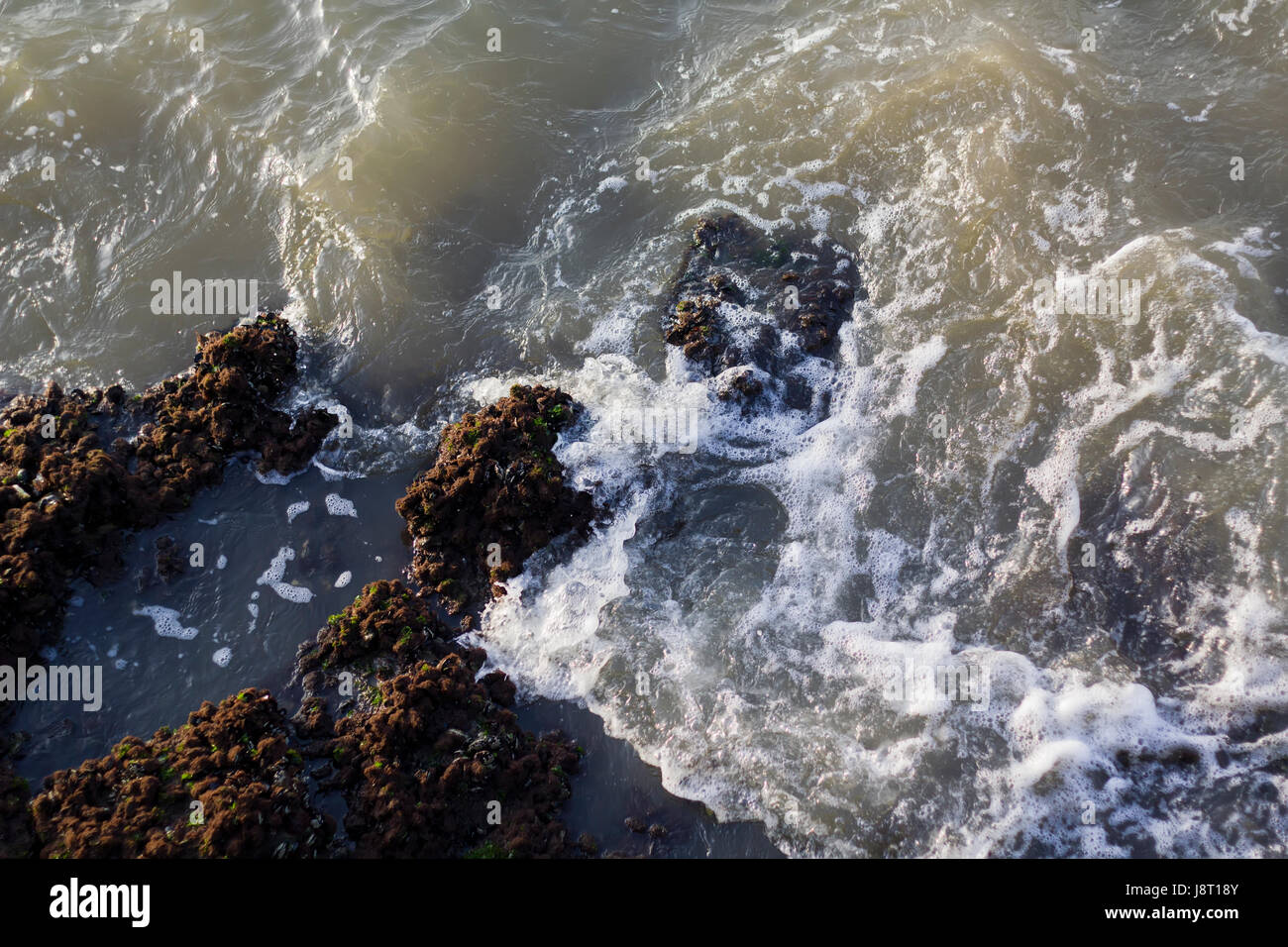 Above view of Waves crashing against rock Stock Photo - Alamy