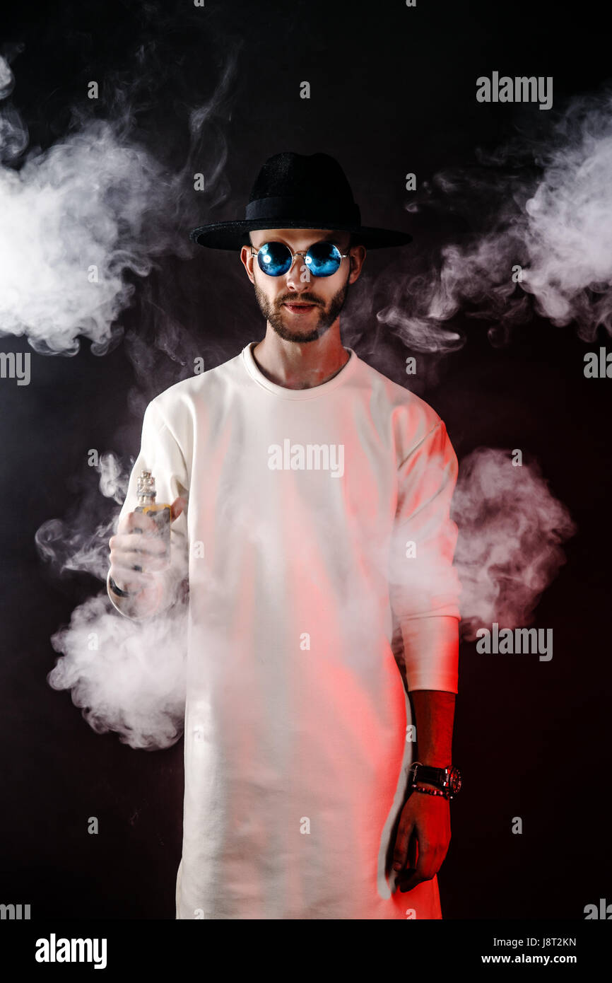 Stylish man in hat vaping Stock Photo - Alamy
