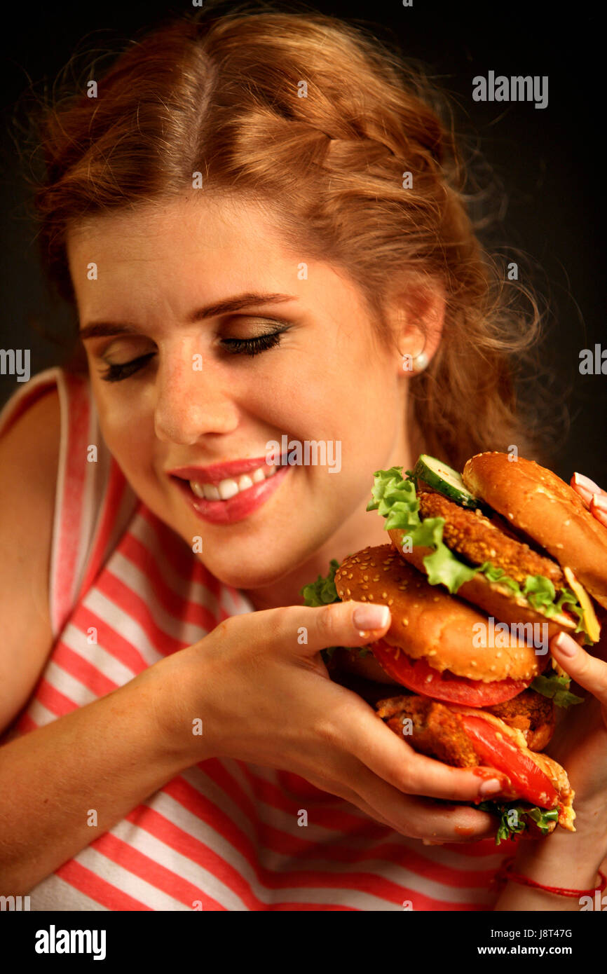 Woman eating burger and winks. Happy student eat sandwich lunch Stock ...