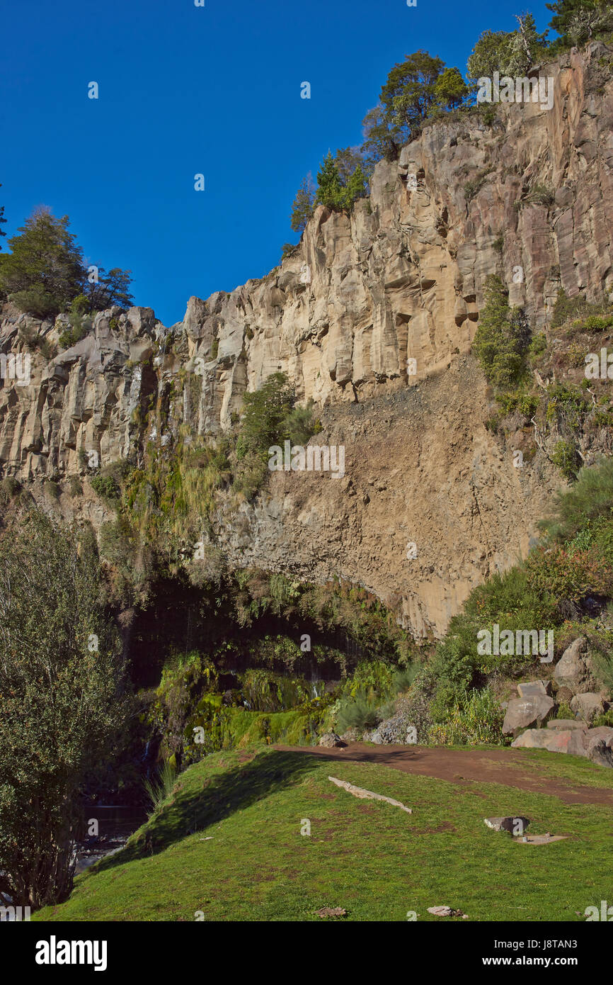 Colourful cliffs rising above a grassy plain on the entry to Laguna de ...