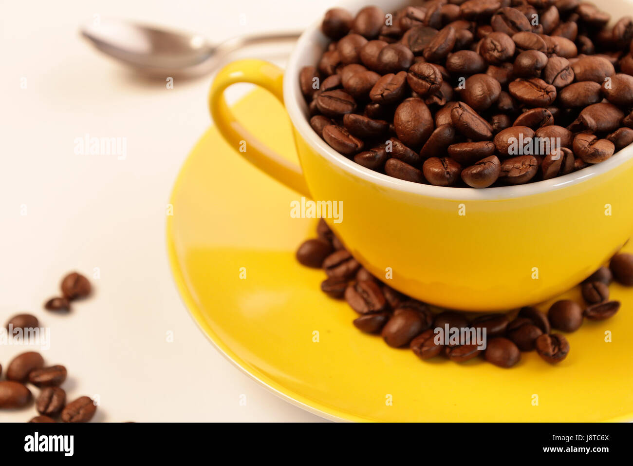 yellow coffee cup with coffee beans Stock Photo - Alamy