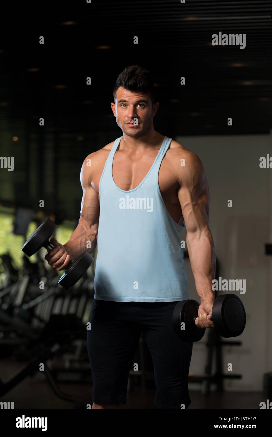 Healthy Man Working Out Biceps In A Fitness Center Gym - Dumbbell ...
