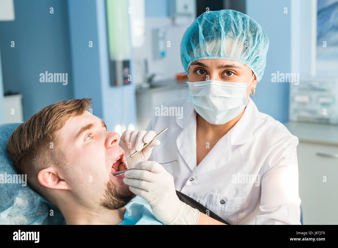 Dentist doing a dental treatment on a patient Stock Photo - Alamy