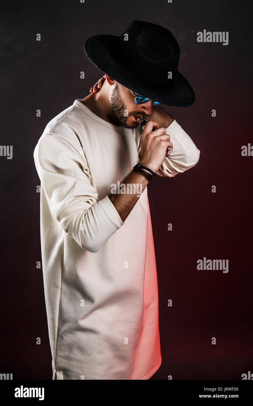 Stylish man in hat vaping Stock Photo - Alamy