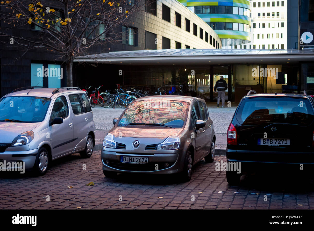 An office block is reflected in the window of a parked car in Berlin ...