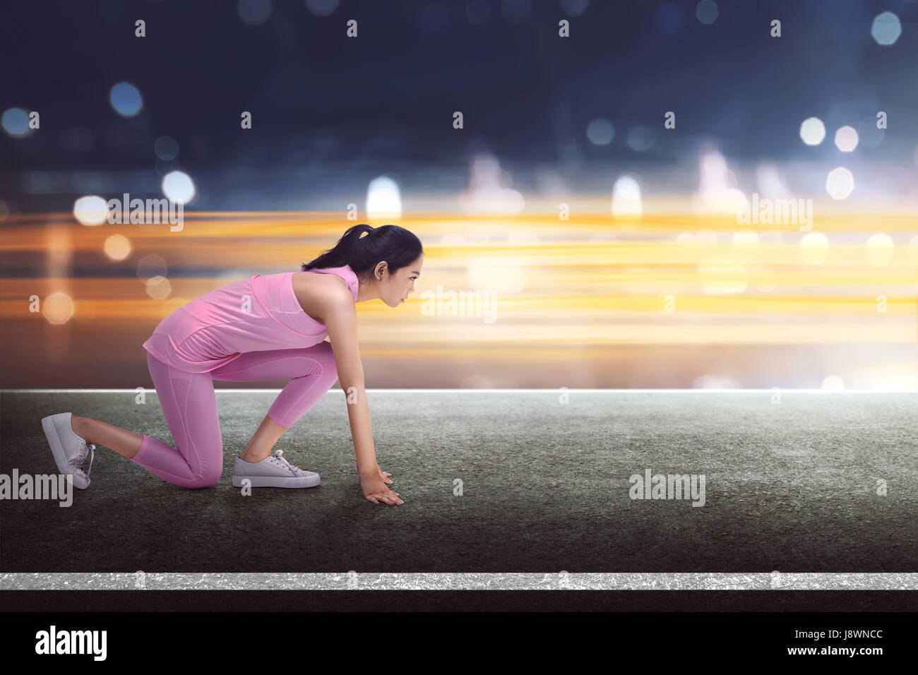 Beautiful asian woman athlete in start position ready to running on ...