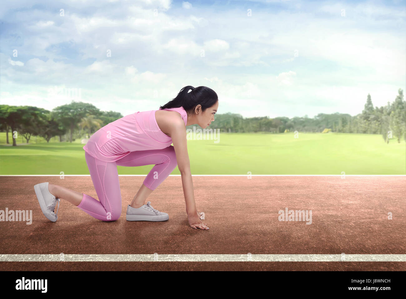 Athlete asian woman runner in ready position ready to run on running ...