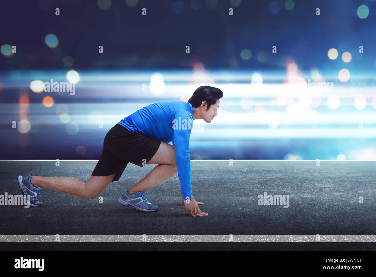 Handsome asian man runner with ready position for running on asphalt ...