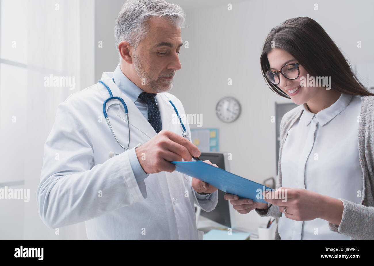 Doctor explaining medical test results to the patient, he is pointing ...