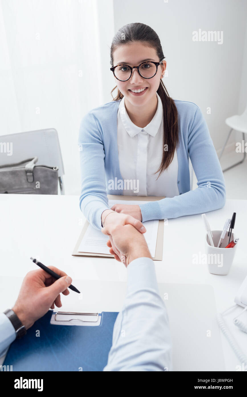 Young smart woman having a successful job interview, the examiner is ...
