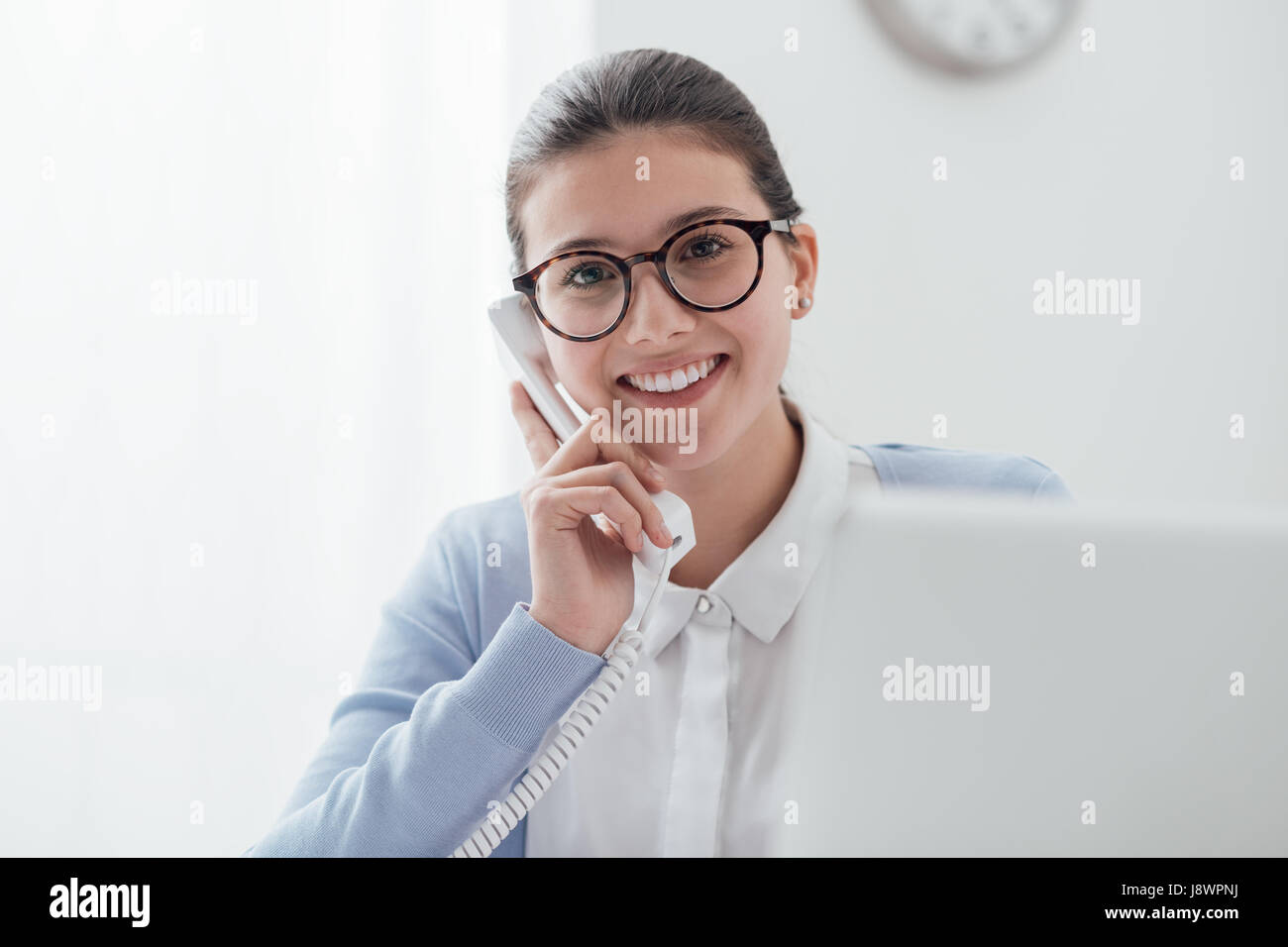 Efficient smiling secretary answering phone calls and talking with ...
