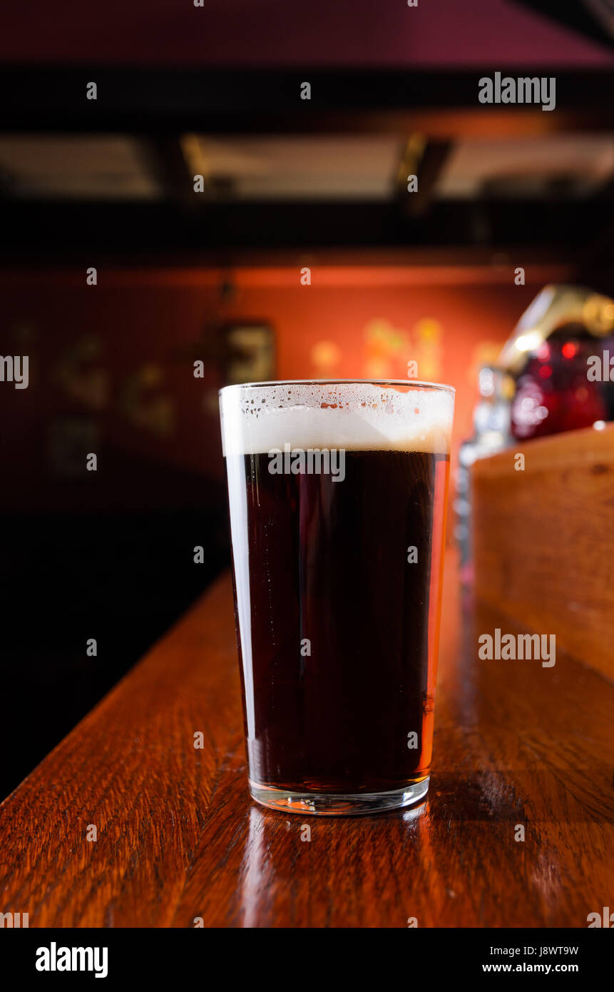 Glass of fresh beer on counter in pub Stock Photo - Alamy