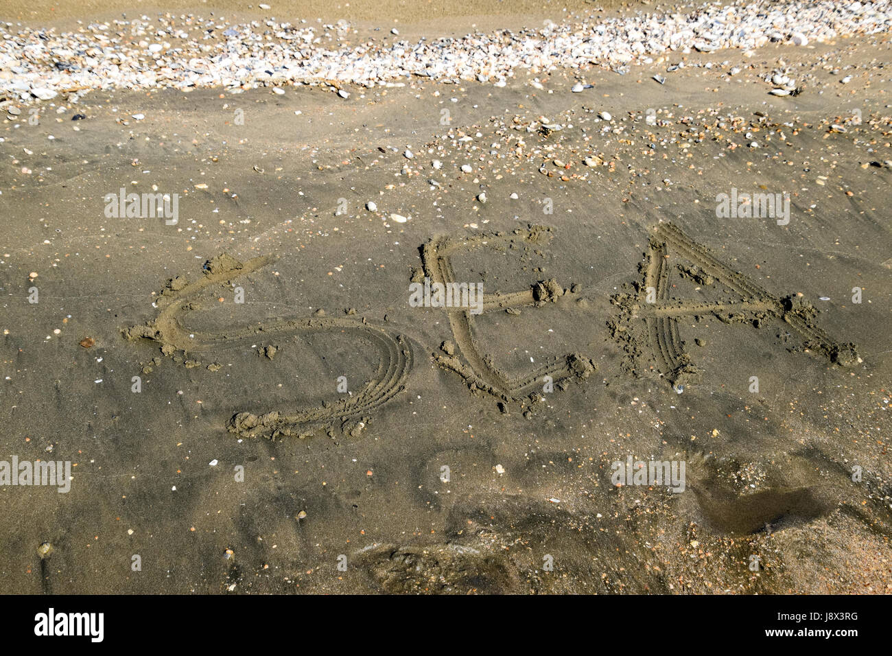 The inscription of the sea on the sand. Coastal sand and waves ...