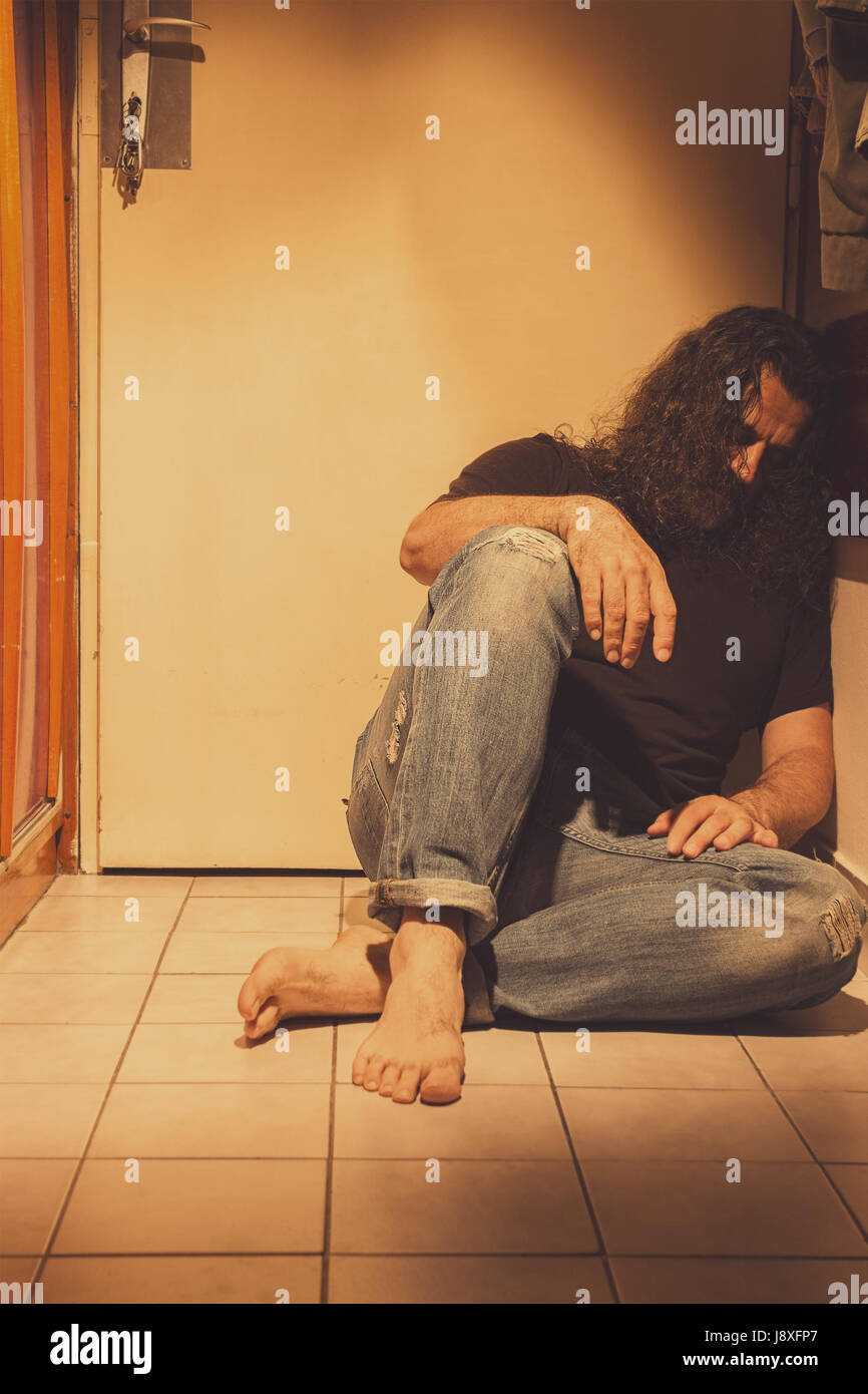 Man sitting on a floor tiles, sad, depressed and lonely, crying Stock ...