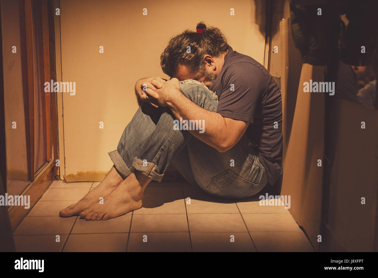 Man sitting on a floor tiles, sad, depressed and lonely, crying Stock ...