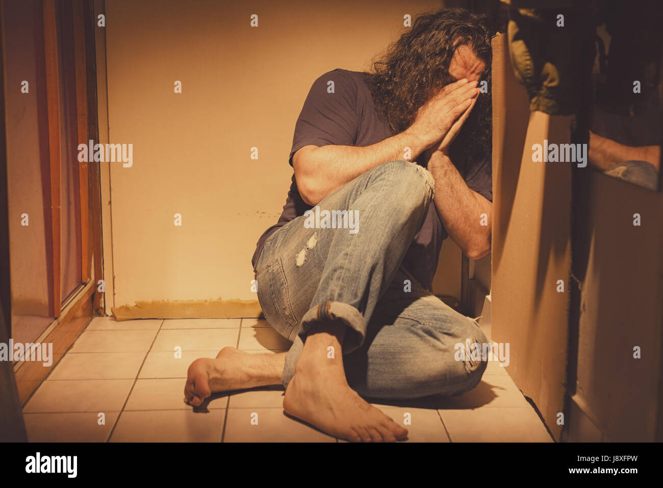 Man sitting on a floor tiles, sad, depressed and lonely, crying Stock ...