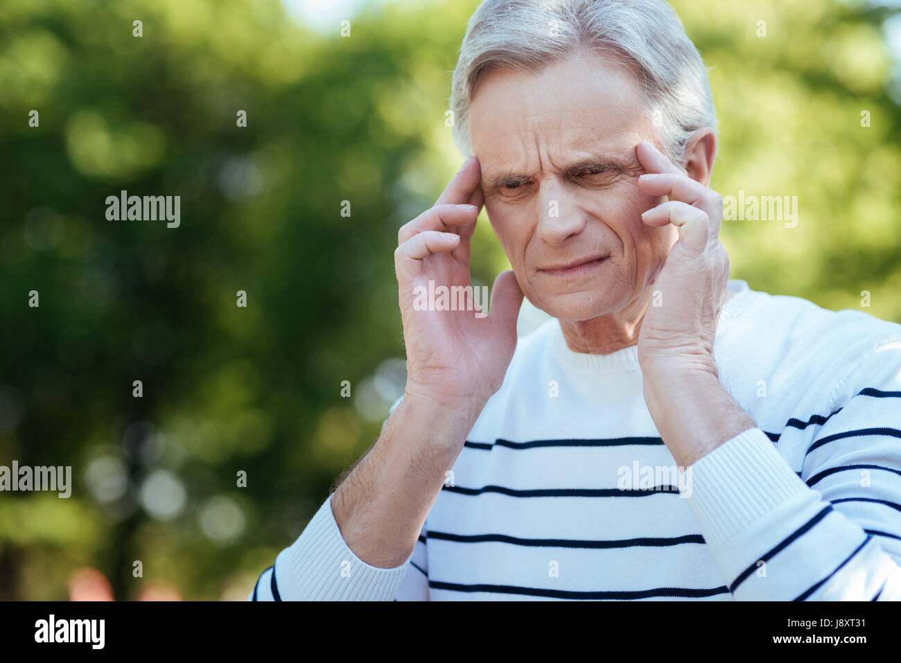 Confused pensioner feeling terrible headache outdoors Stock Photo - Alamy