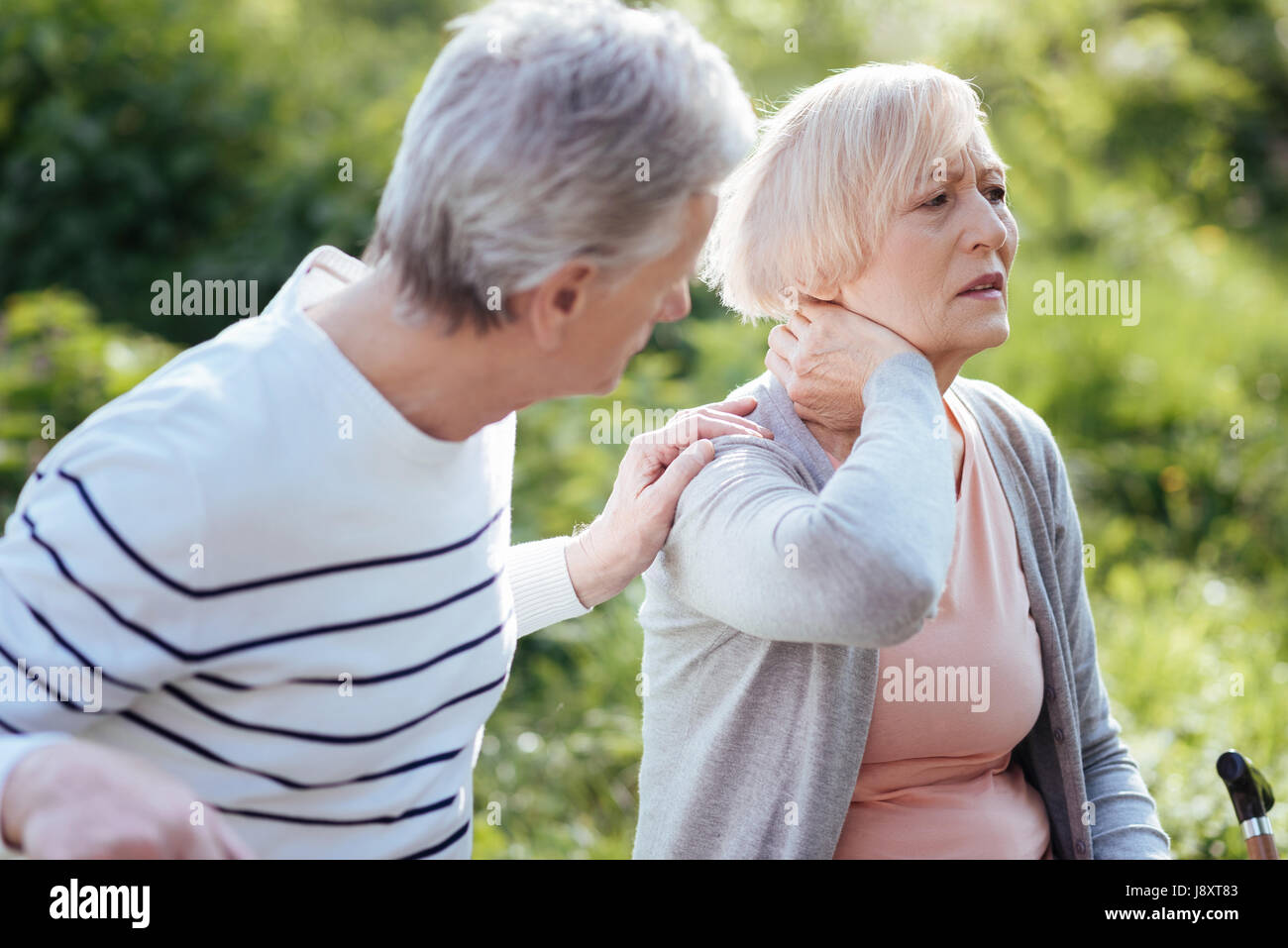 Distracted pensioner feeling terrible pain in the neck outdoors Stock ...