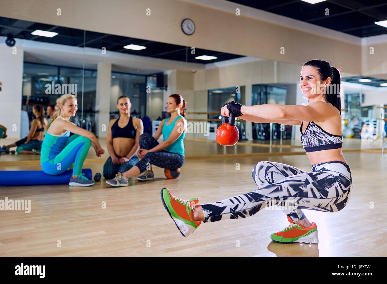 Beautiful girl doing sit-ups on one leg in the gym Stock Photo - Alamy
