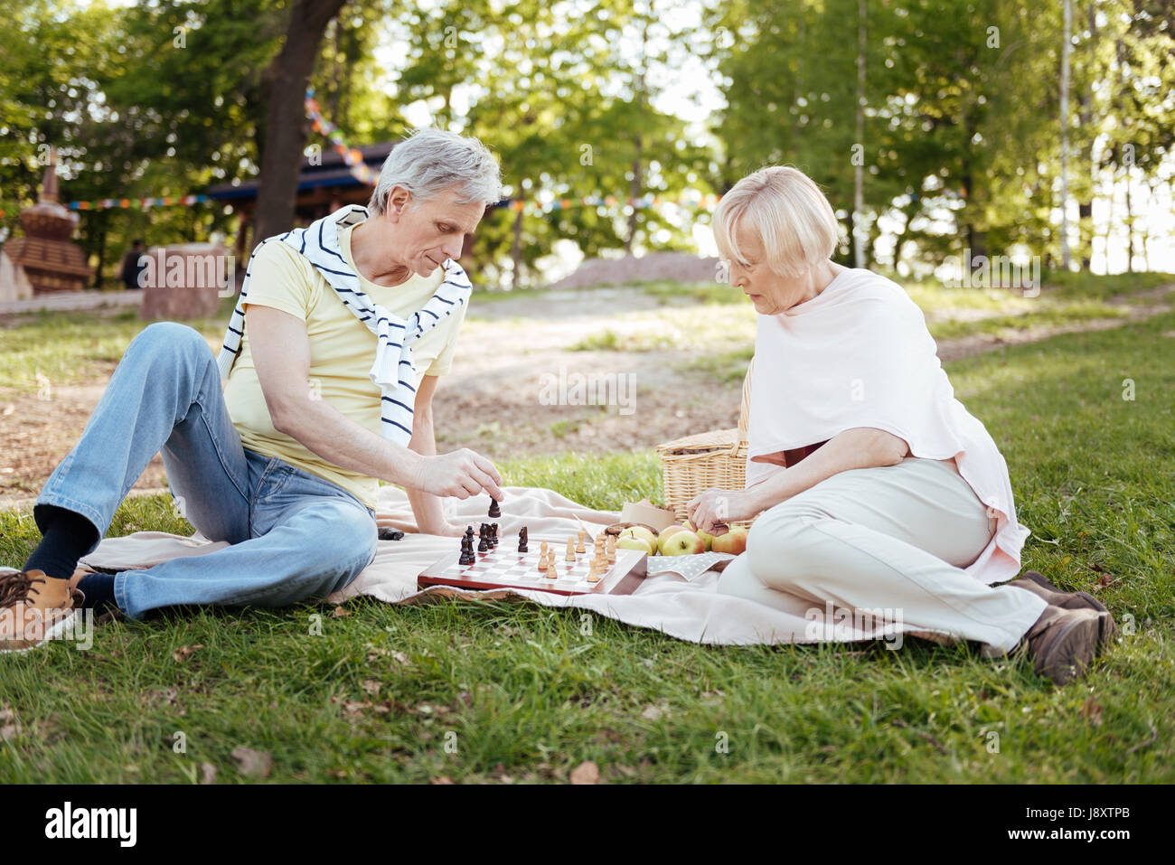 Calm aged couple playing chess at the picnic Stock Photo - Alamy