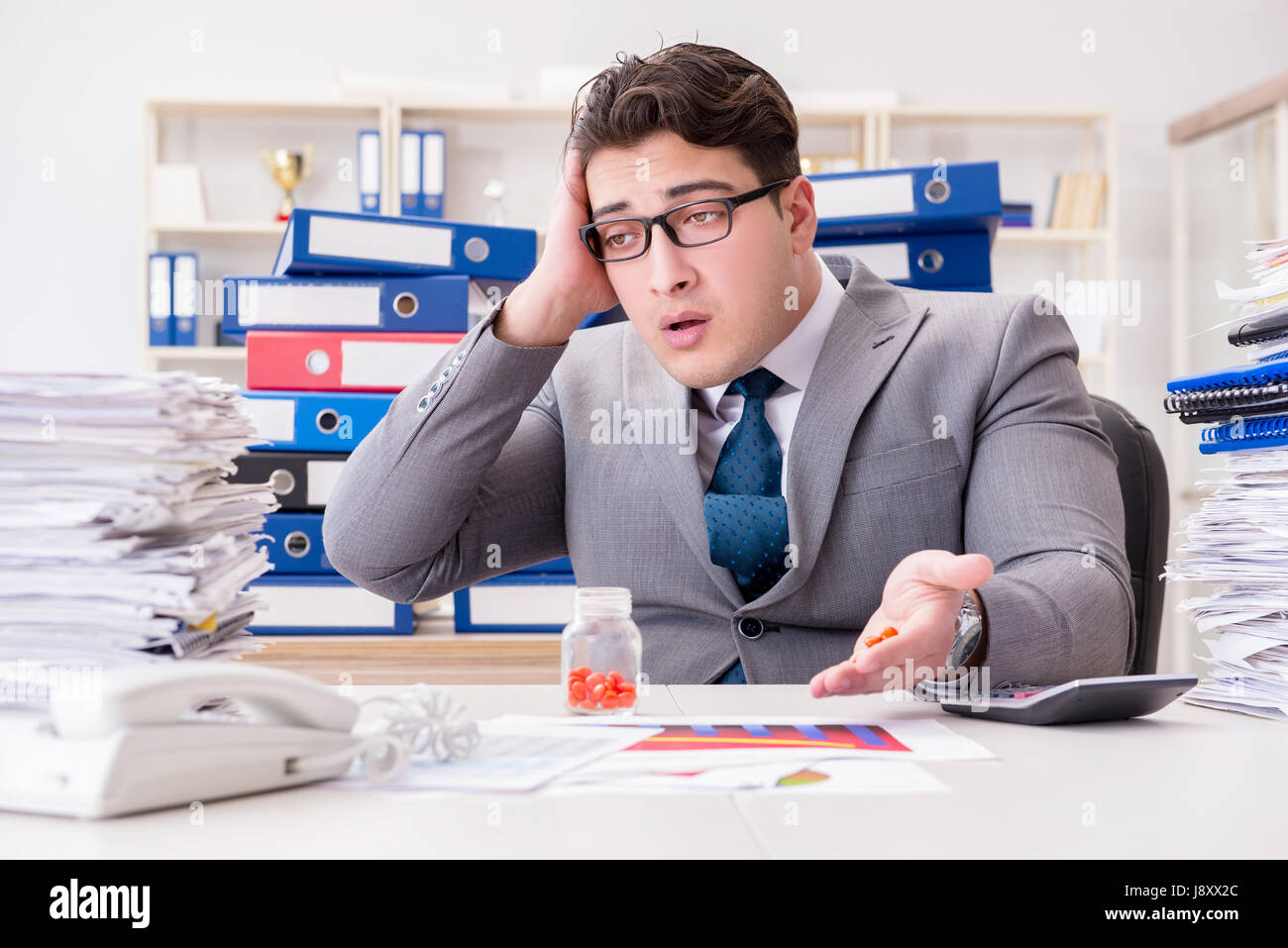 Businessman taking pills to cope with stress Stock Photo - Alamy