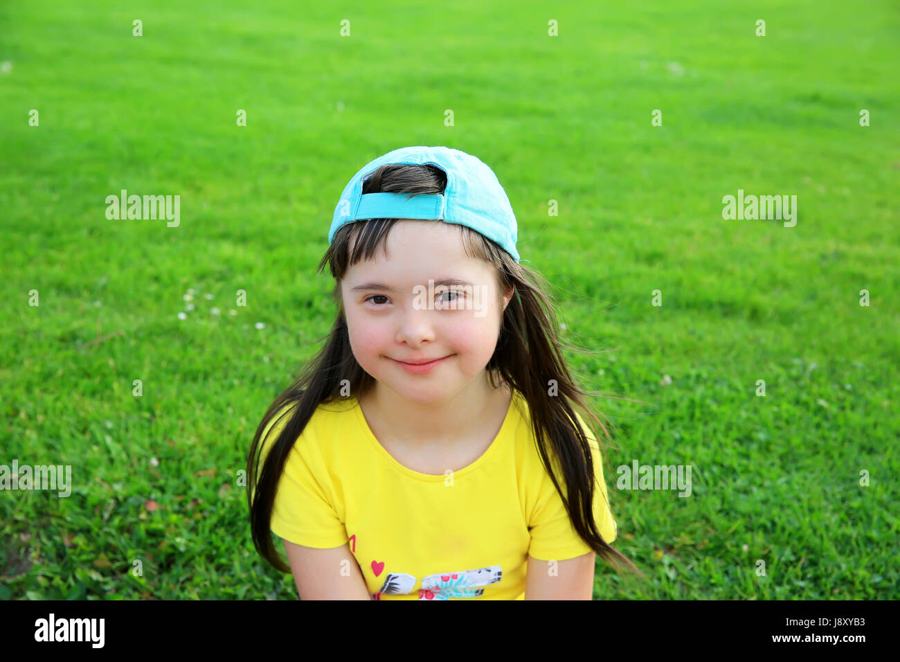 Young girl on the background of green grass Stock Photo - Alamy