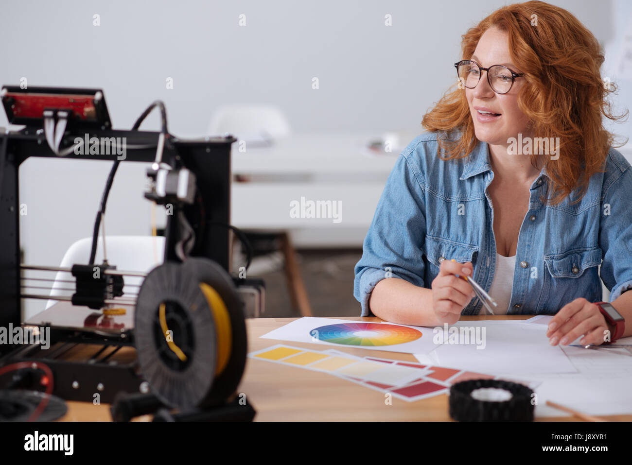 Nice smart woman looking at the 3D printer Stock Photo - Alamy