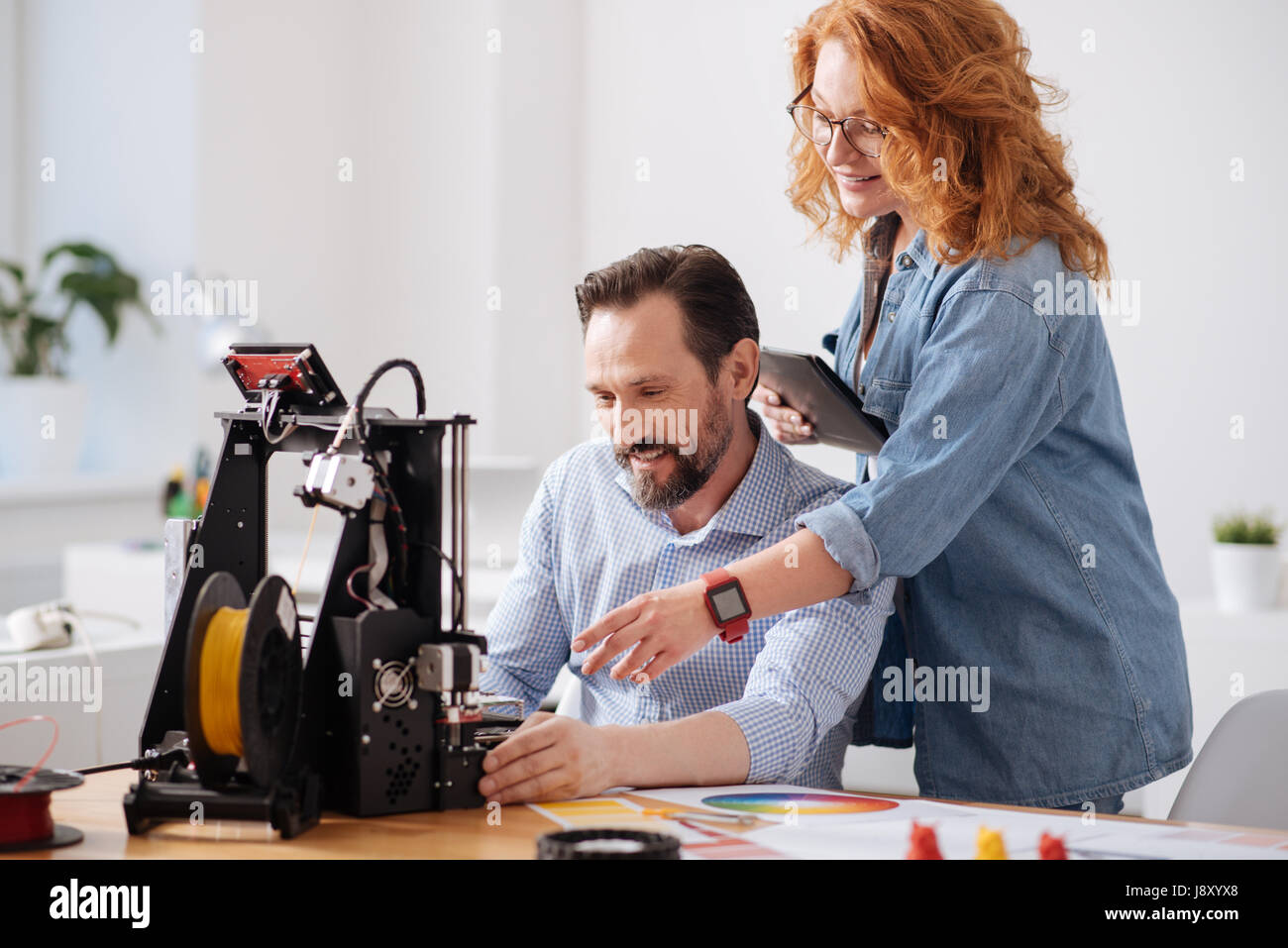 Positive cheerful woman pointing at the 3d printer Stock Photo - Alamy