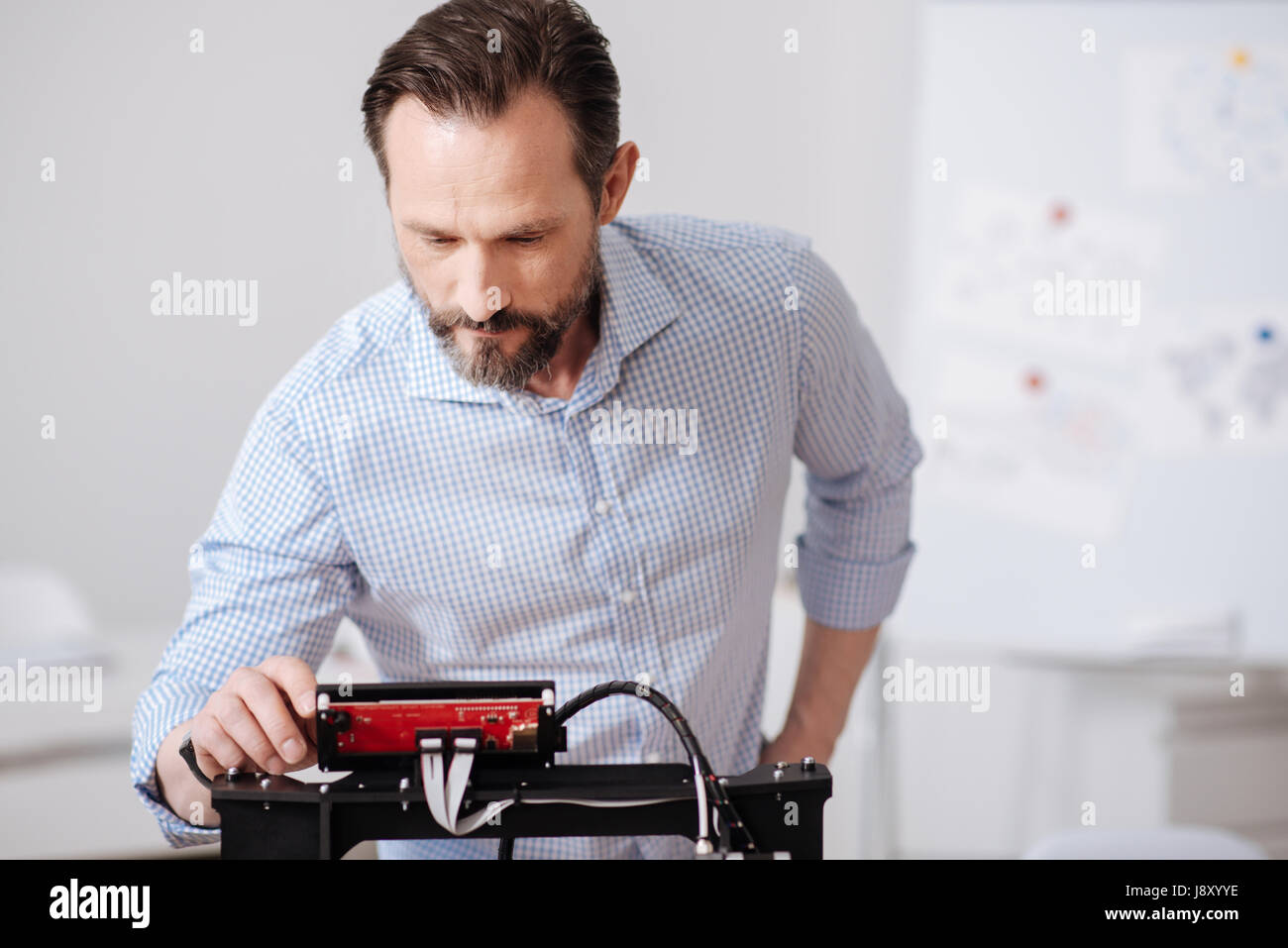 Serious hard working man looking at the 3d printer screen Stock Photo ...