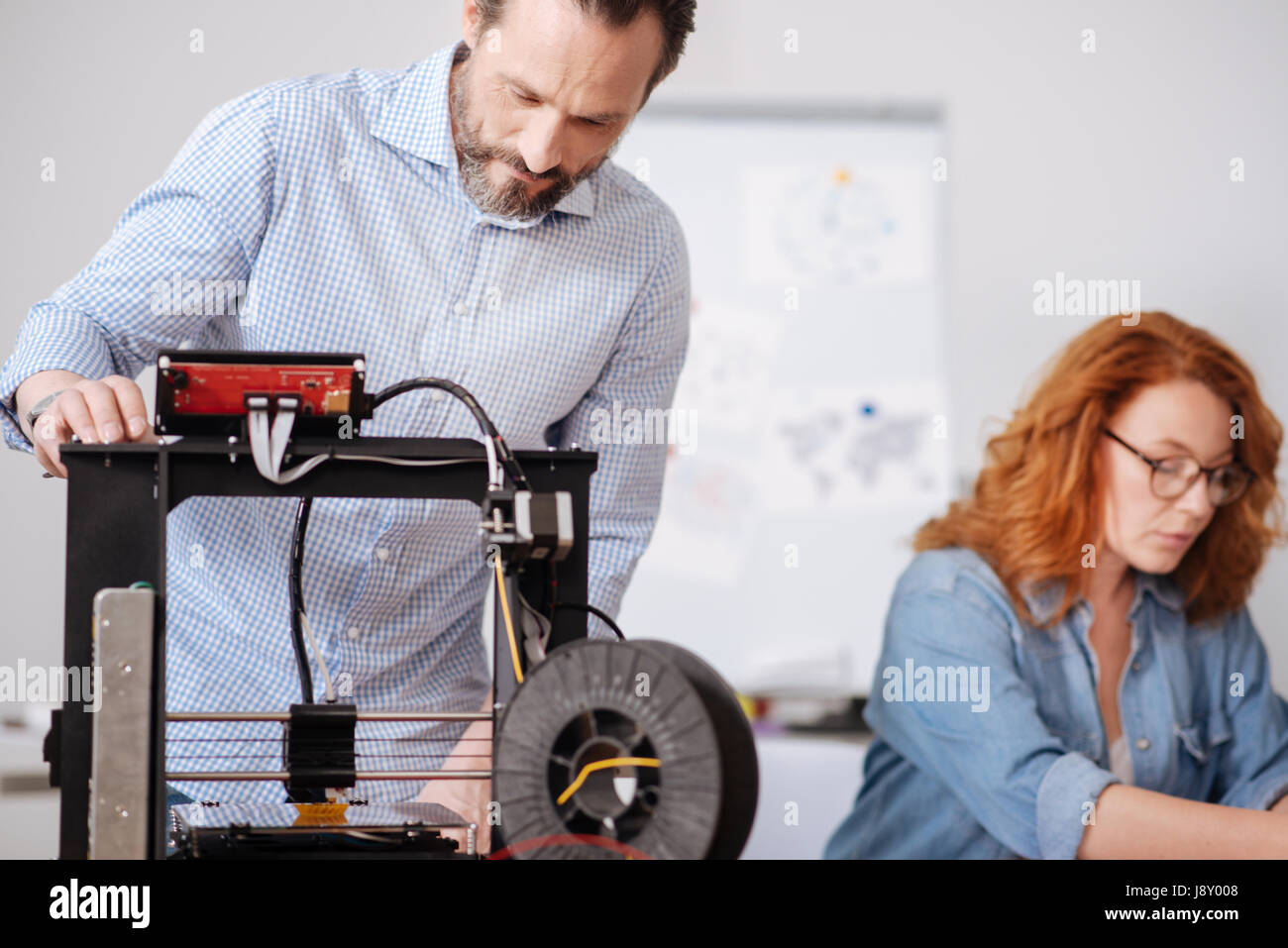 Handsome nice man looking at the 3d printer Stock Photo - Alamy