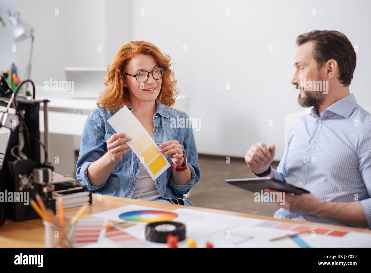 Attractive smart designer choosing the colour Stock Photo - Alamy