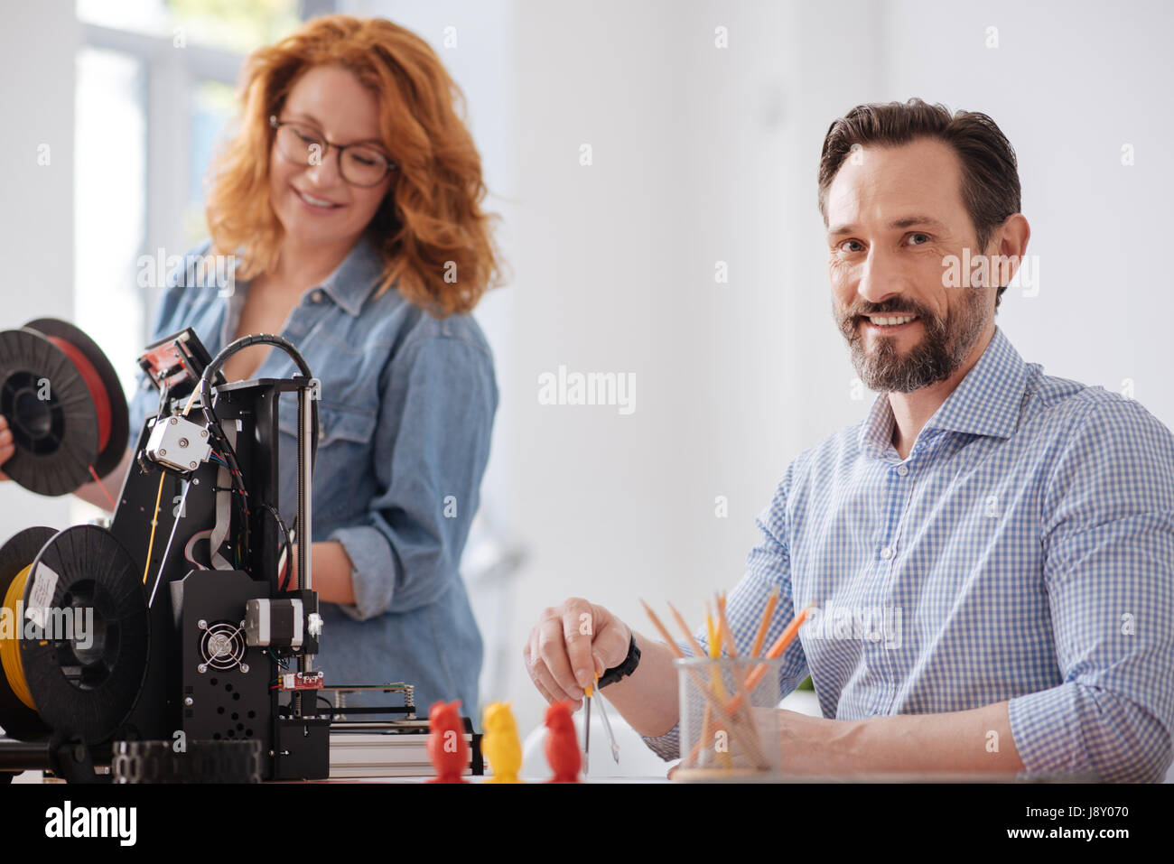 Cheerful joyful man drawing with a pair of compasses Stock Photo - Alamy
