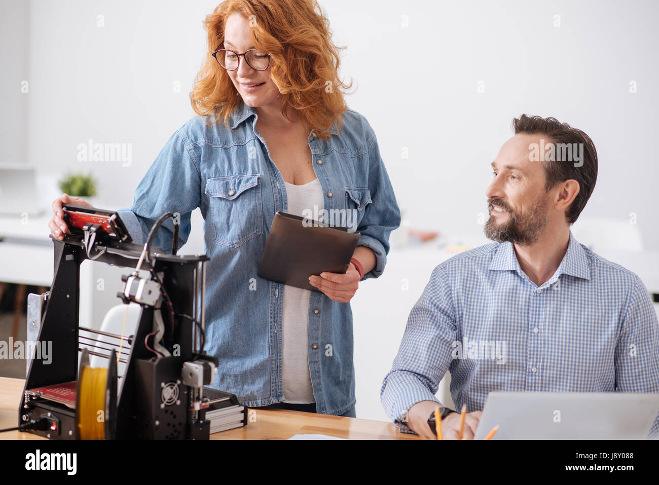 Delighted professional designer looking at the 3d printer display Stock ...