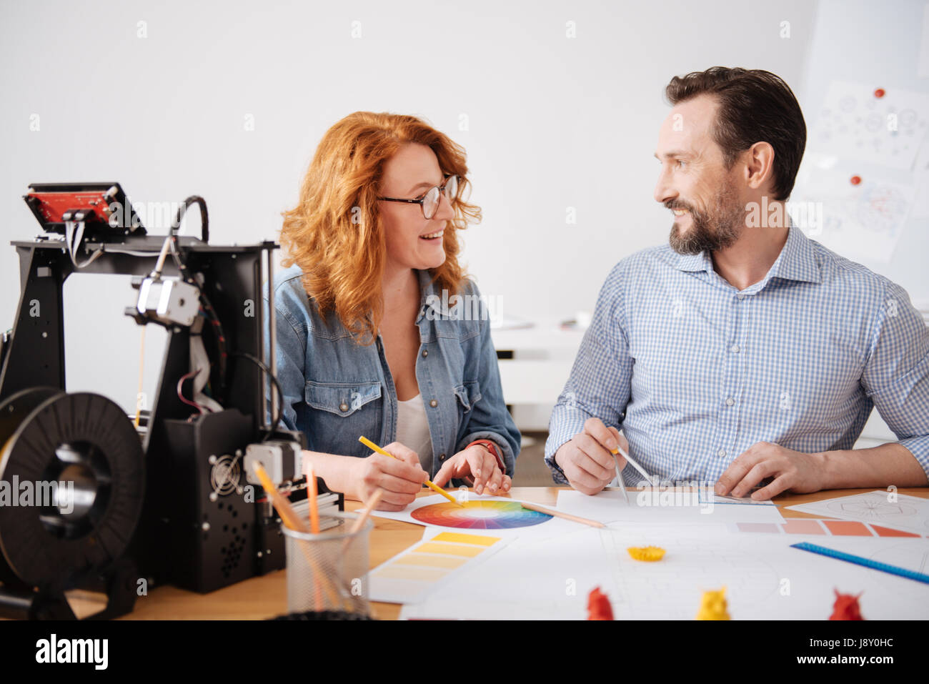Happy positive colleagues looking at each other Stock Photo - Alamy