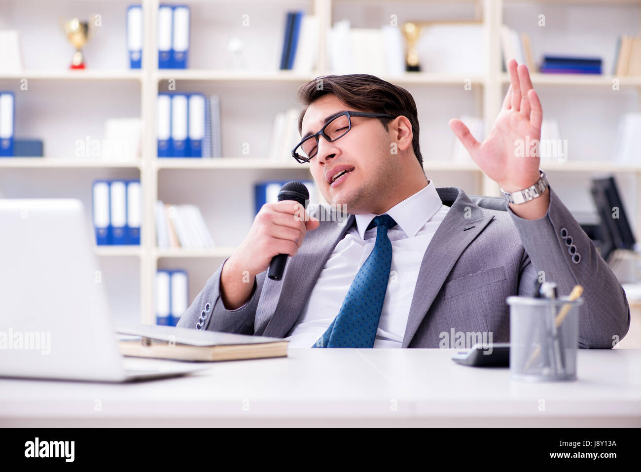 Businessman singing in the office Stock Photo - Alamy