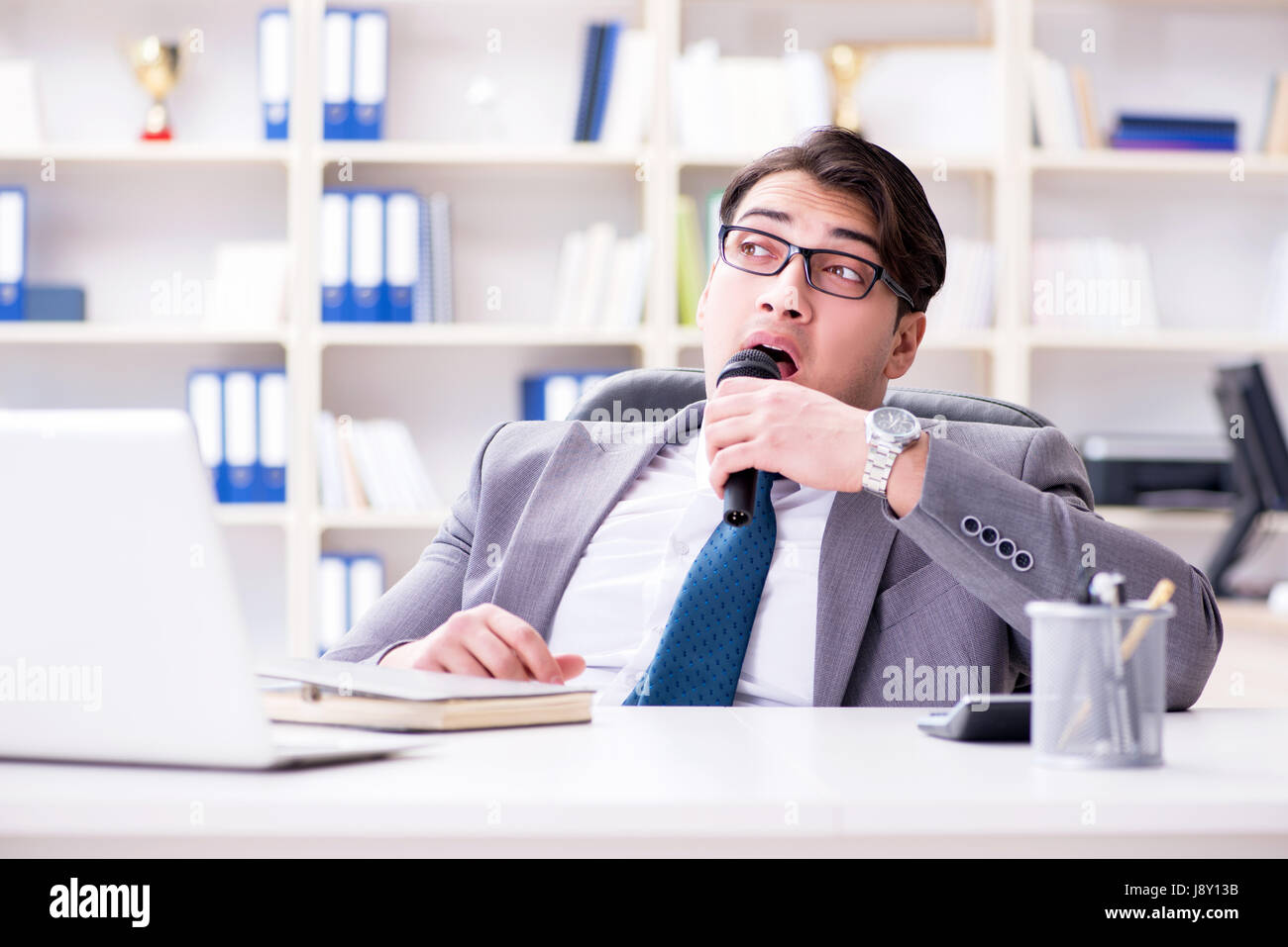 Businessman singing in the office Stock Photo - Alamy