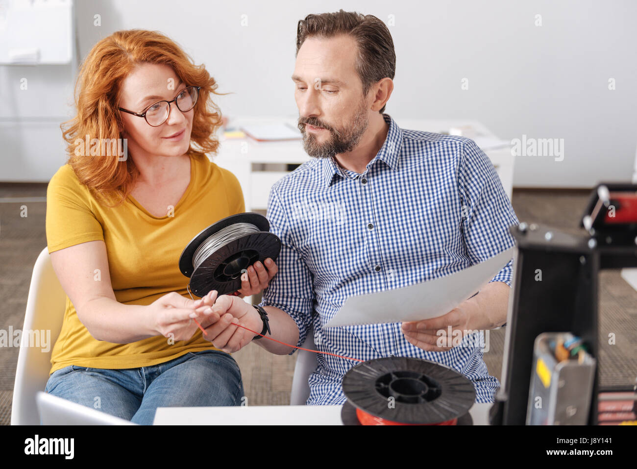 Pleasant nice woman helping her colleague Stock Photo - Alamy
