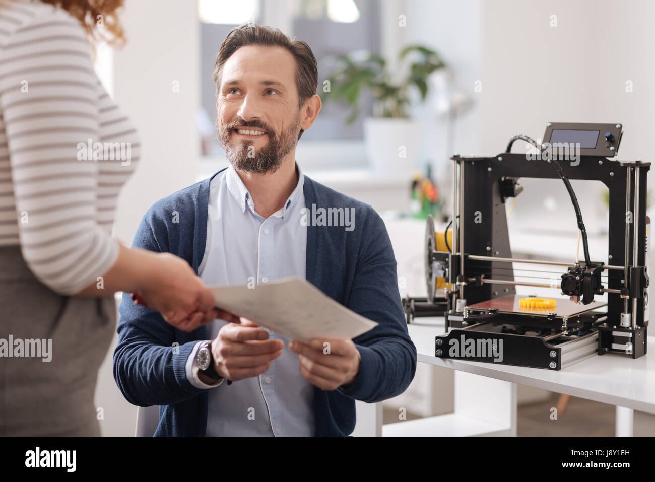 Joyful handsome man sitting in front of the 3d printer Stock Photo - Alamy