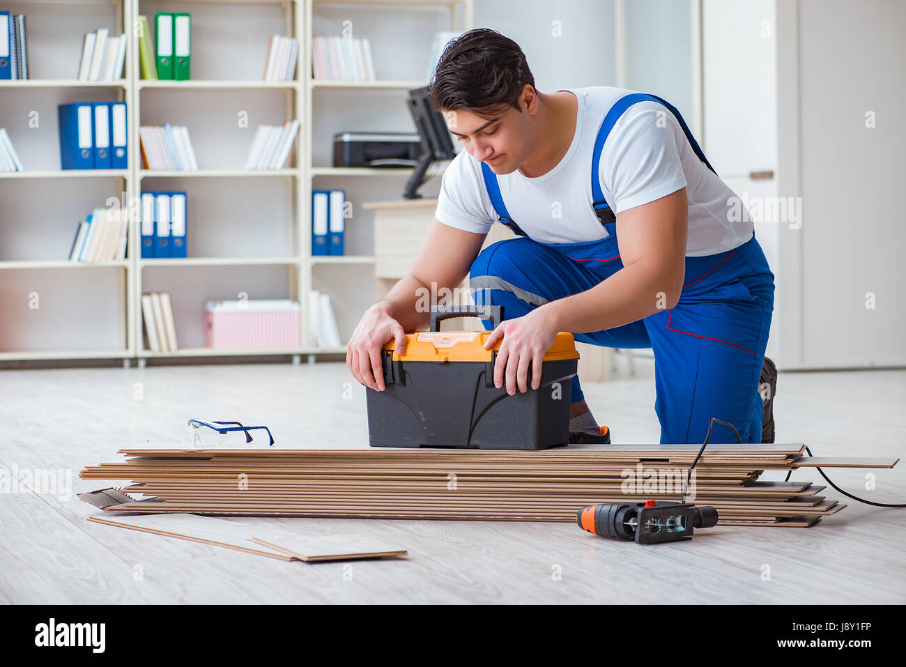 Young worker working on floor laminate tiles Stock Photo - Alamy