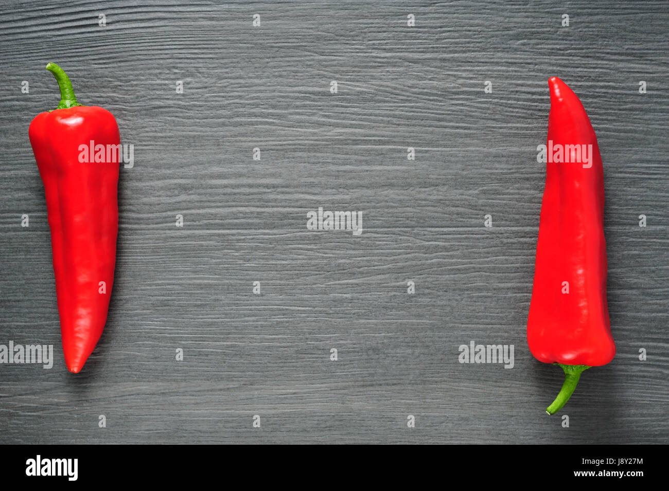 Two red Kapia peppers on a dark shale stone background Stock Photo - Alamy