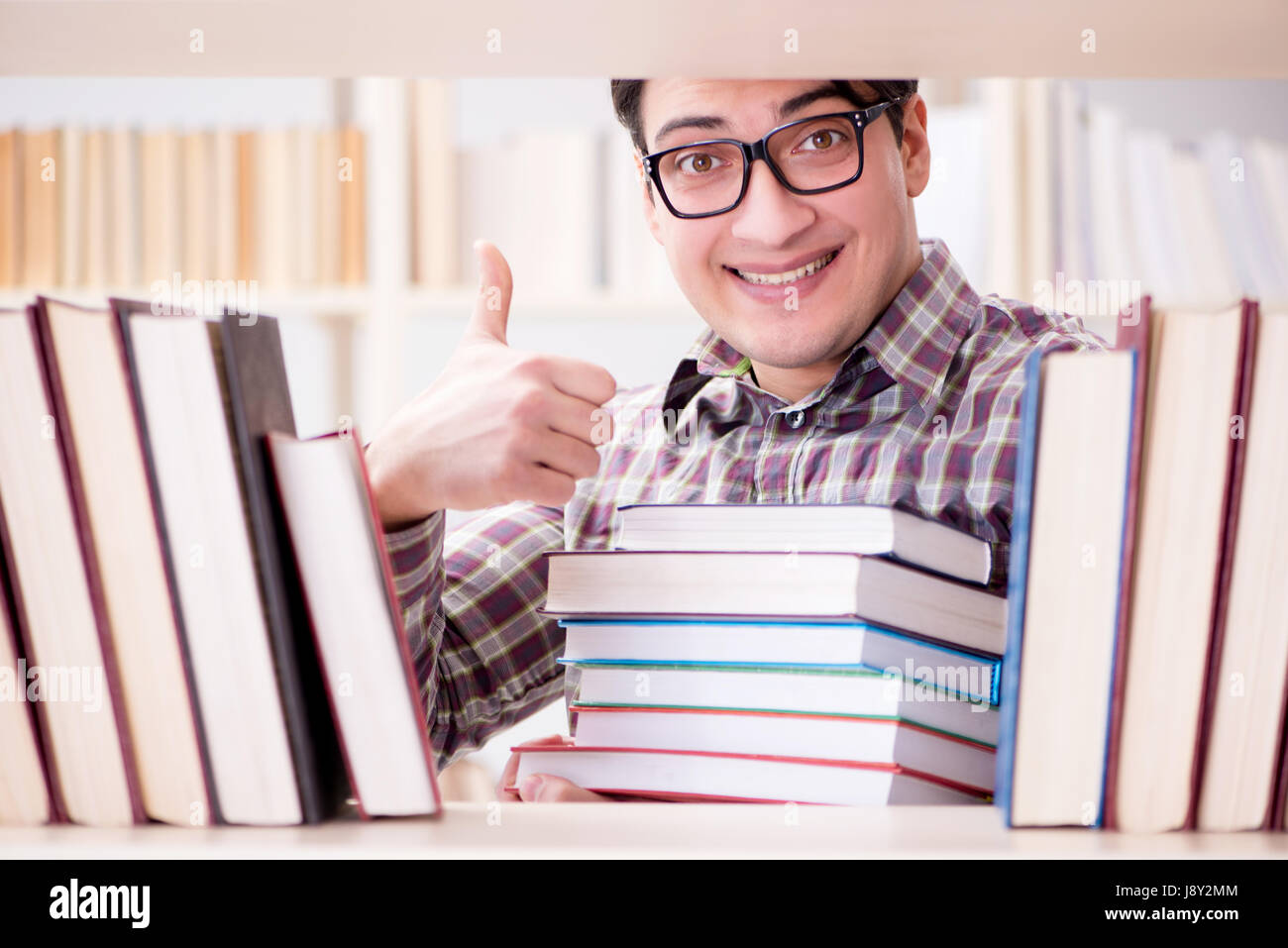Young student looking for books in college library Stock Photo - Alamy