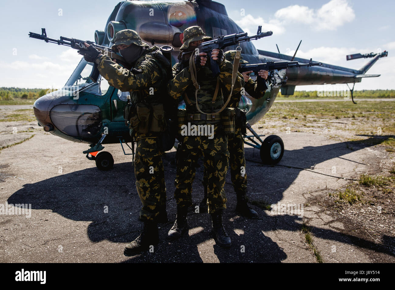 Photos of a group of military men with a gun in front of a helicopter ...