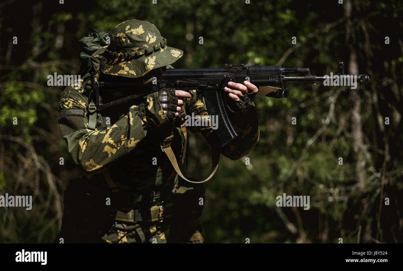 Photo of military man with gun in woods during day Stock Photo - Alamy