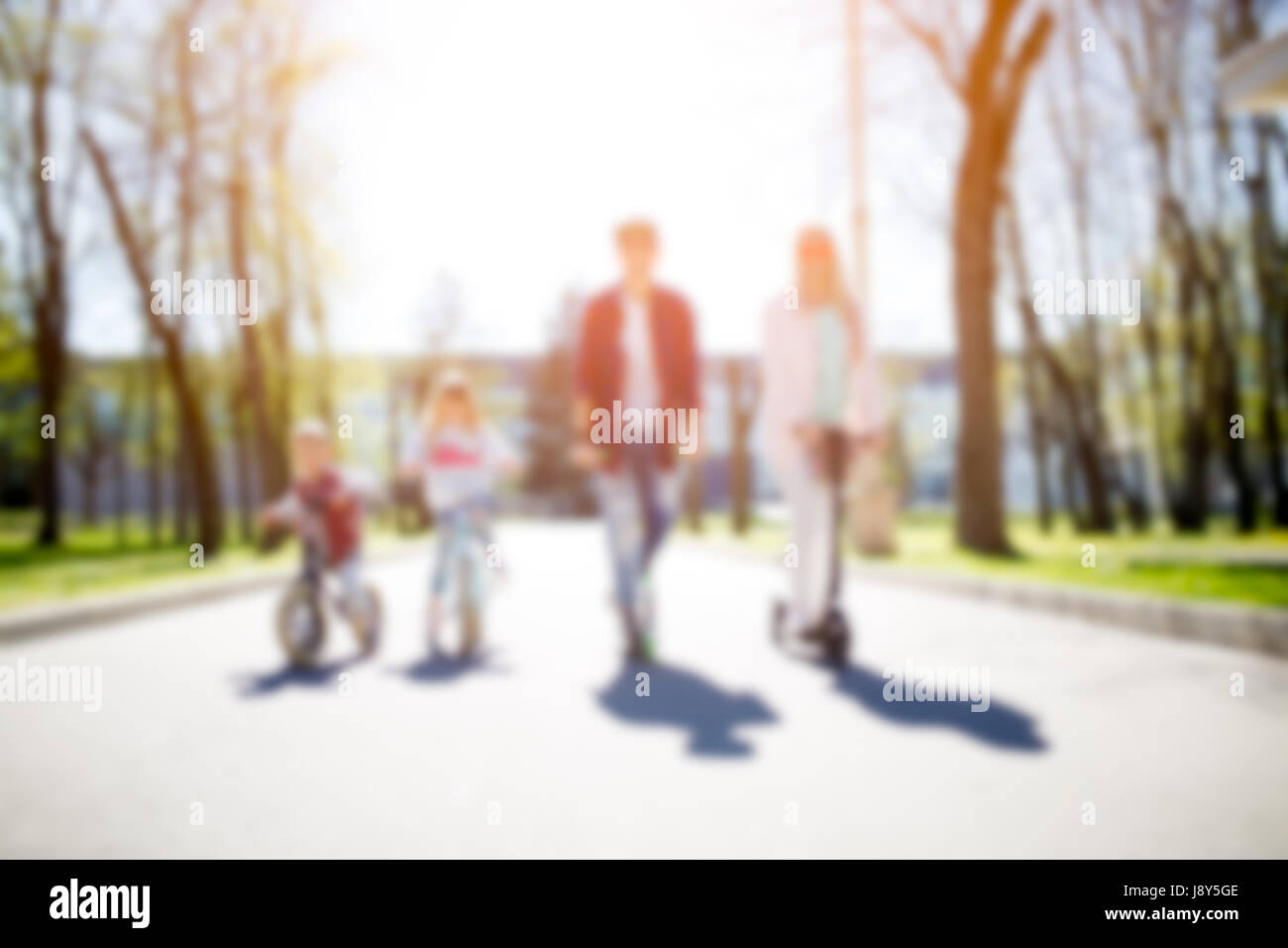 Blurred family photo on bicycles in park during day Stock Photo - Alamy