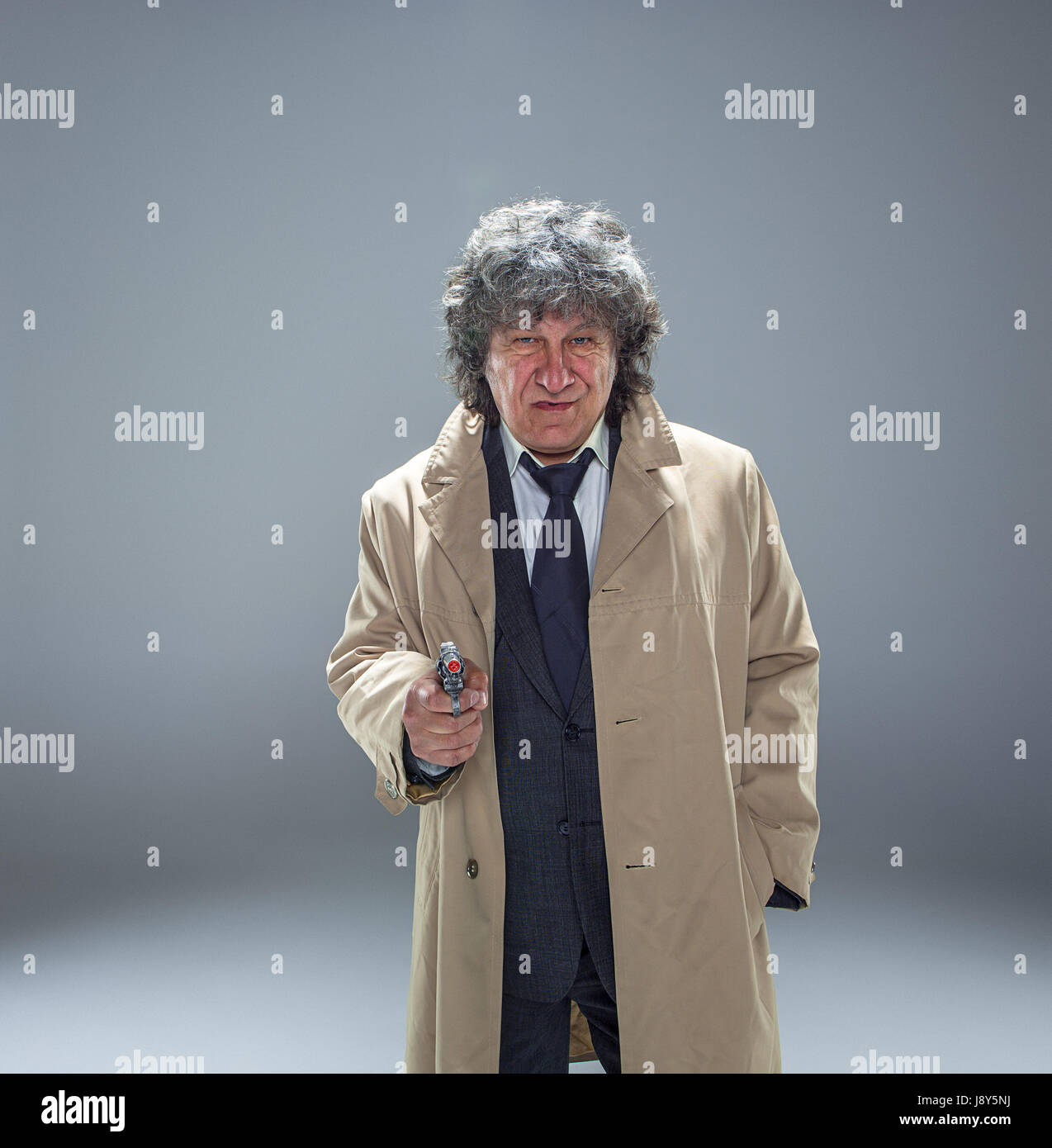 Senior police agent with a gun on studio background Stock Photo - Alamy