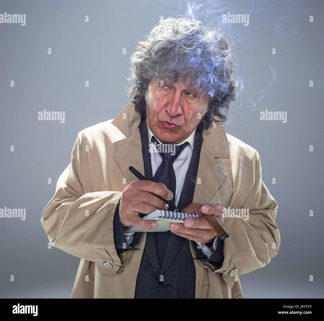 The senior man as detective or boss of mafia on gray studio background ...
