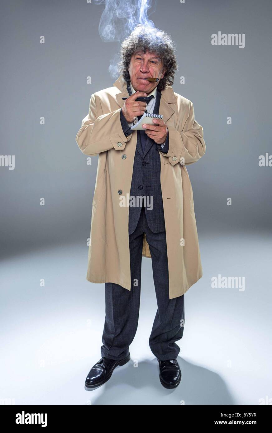 The senior man as detective or boss of mafia on gray studio background ...