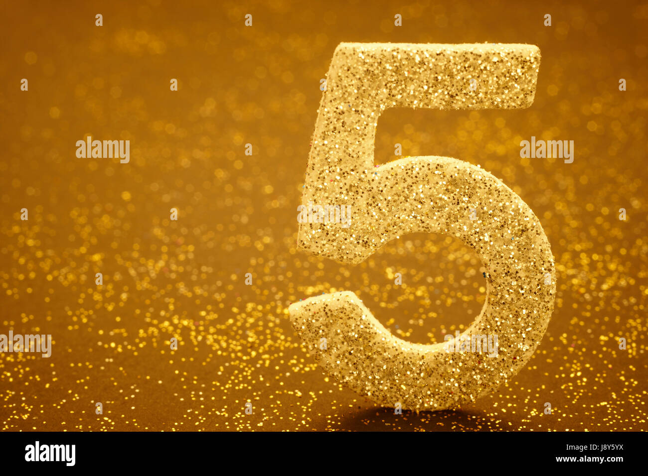 Number five golden color over a warm background. Anniversary ...