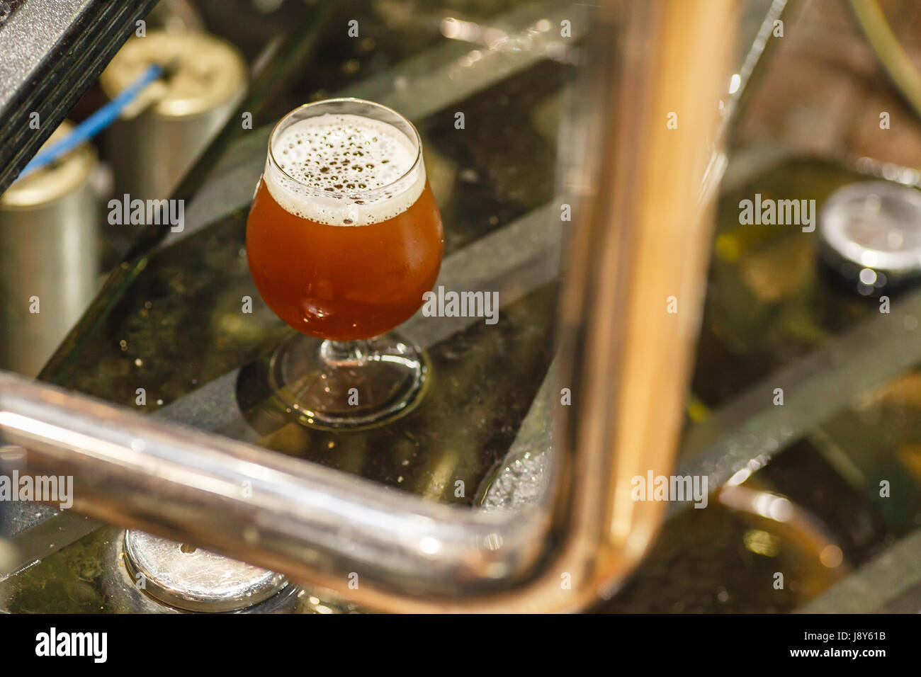 Glass full of amber ale beer standing on steps of an operating ...